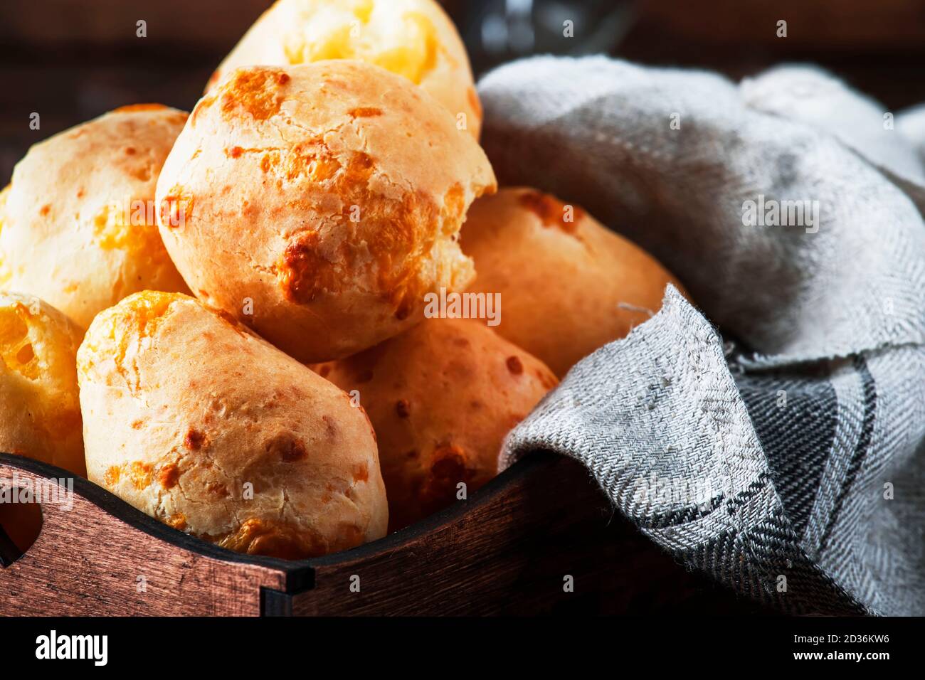 Delicious homemade golden cheese savory buns in tray, vintage wooden ...