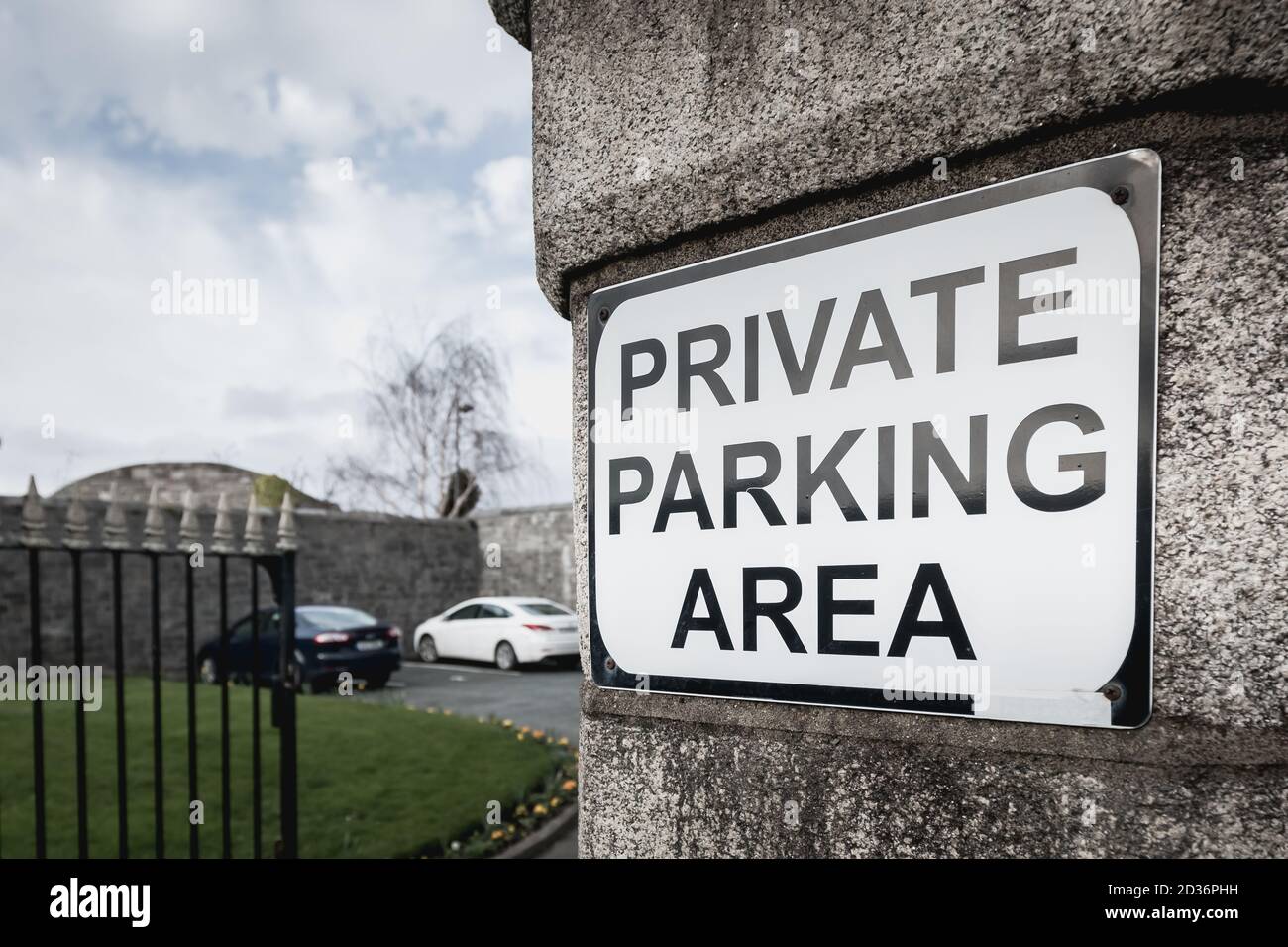 Private Parking Area sign on a stone pillar at the entrance to a car ...