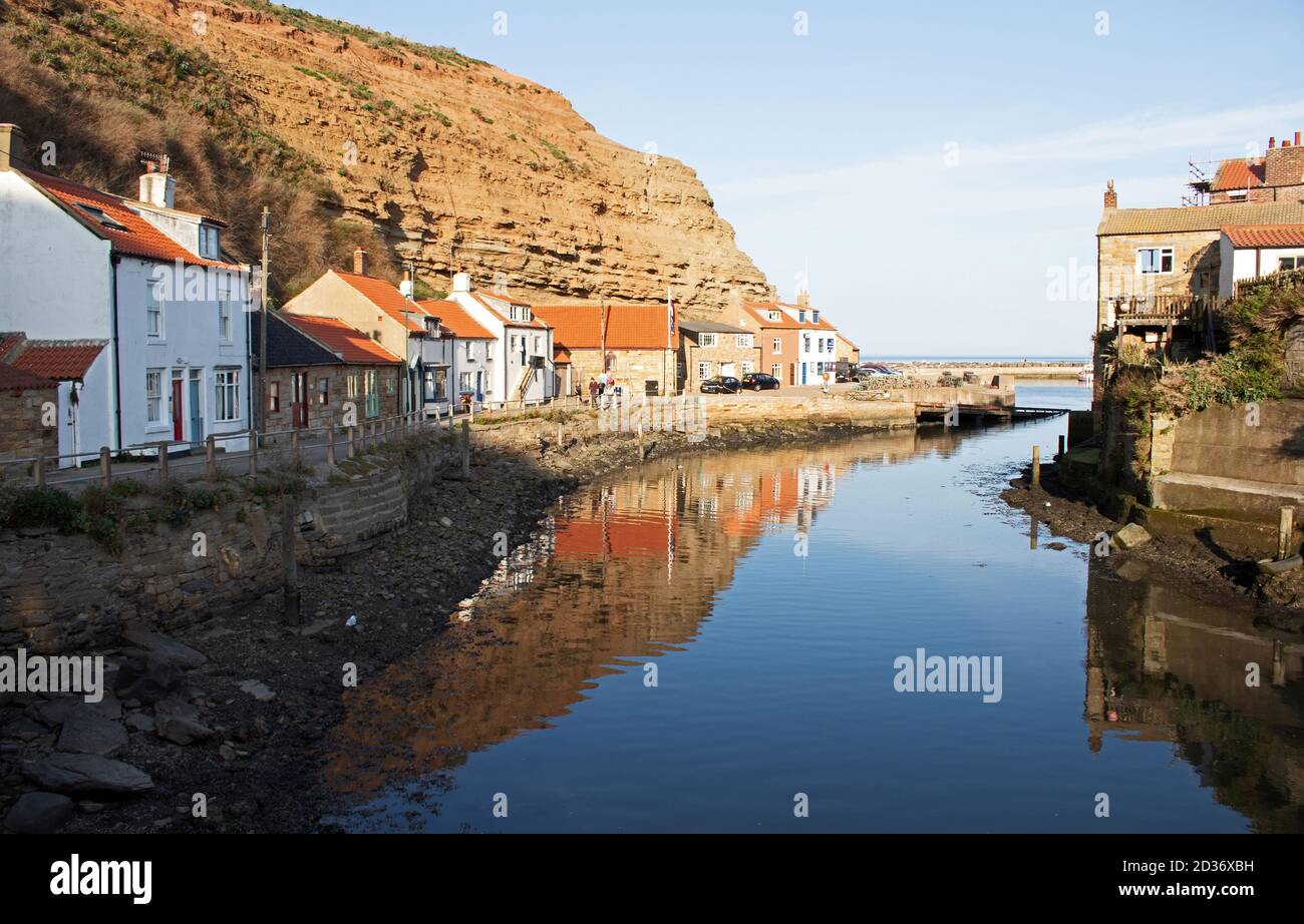 Reflections of houses in Staithes Beck, also known as Roxby Beck. The ...