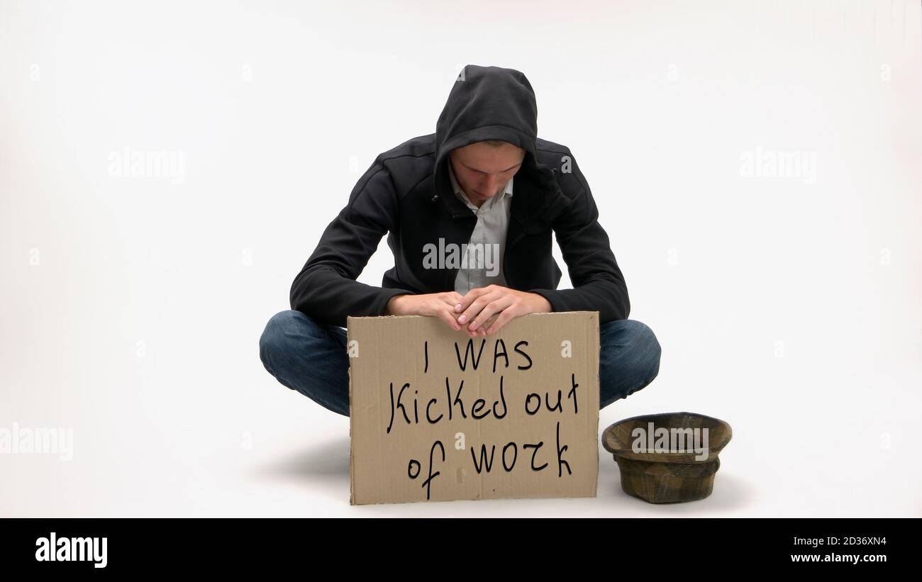 Sad guy begging with donation hat and cardboard sign Stock Photo - Alamy