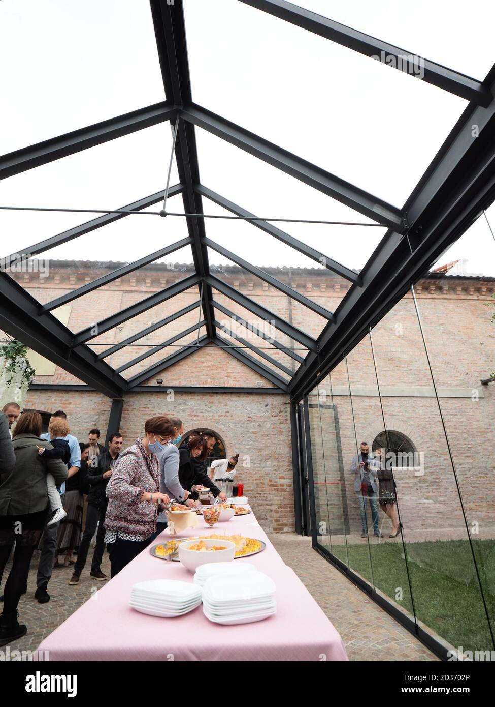 People and catering staff wearing face mask for covid protection at a ...