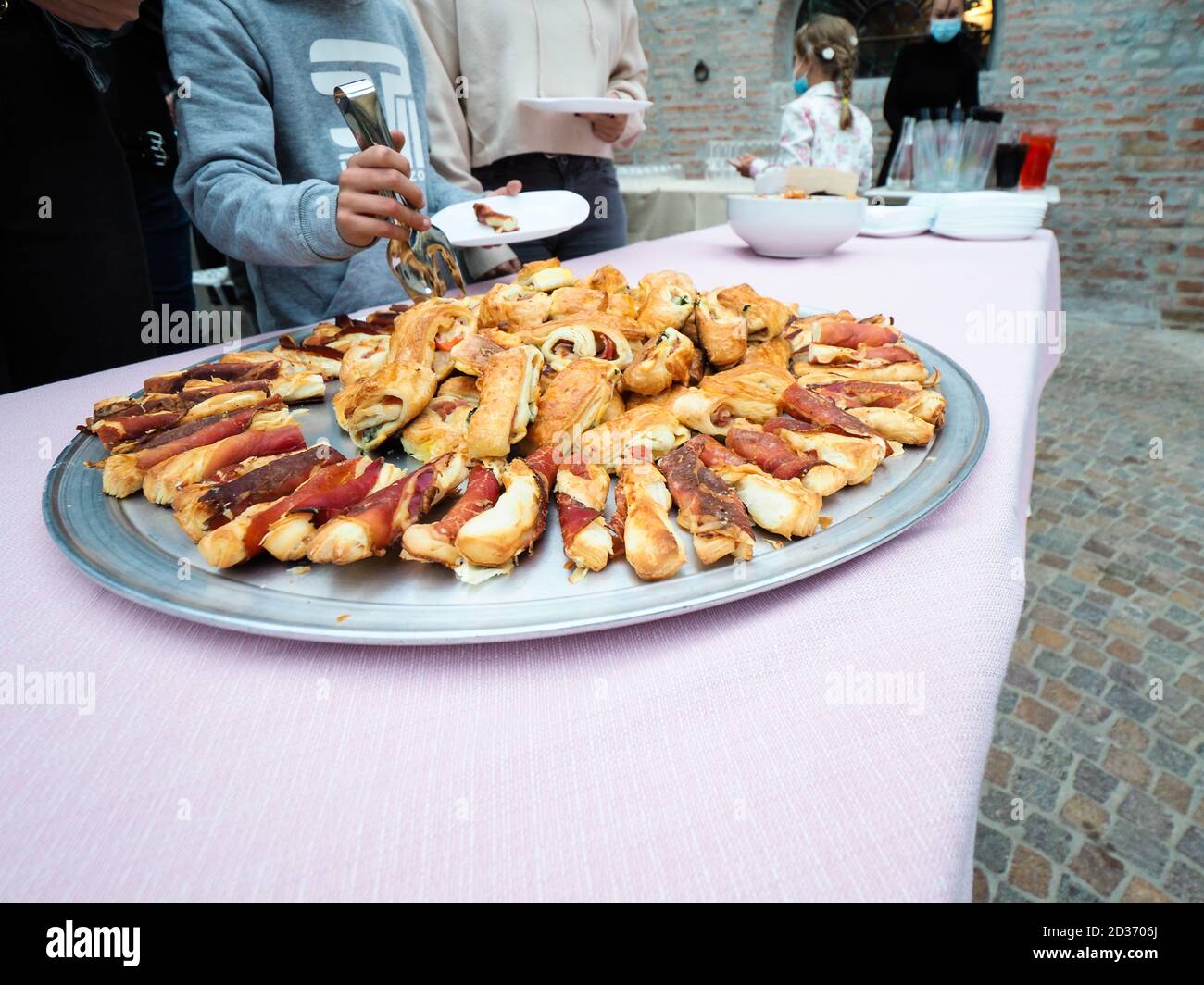 People and catering staff wearing face mask for covid protection at a ...