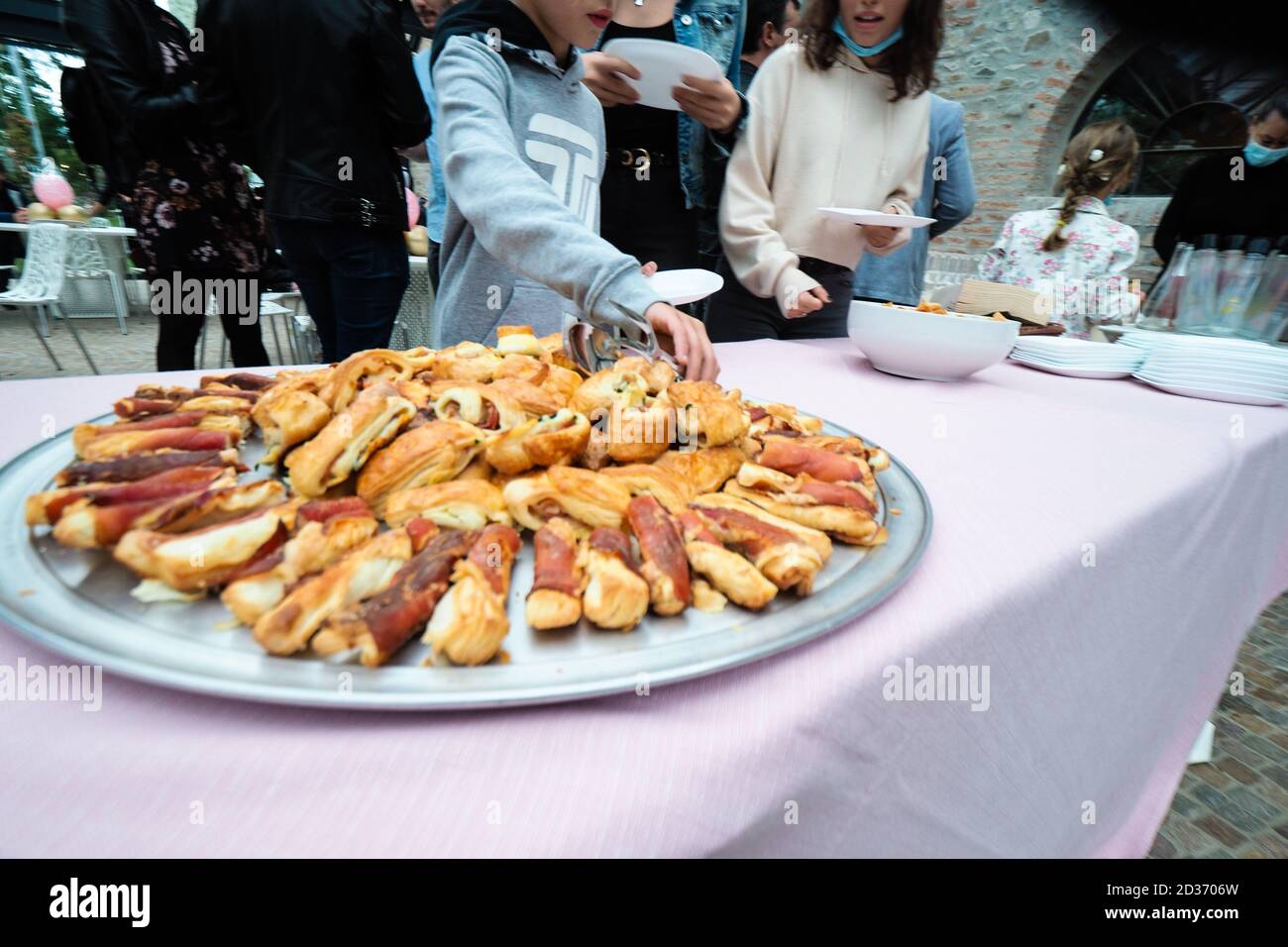 People and catering staff wearing face mask for covid protection at a ...