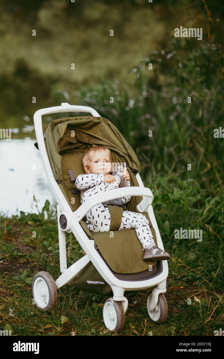Cute healthy little boy sitting in a stroller and waiting for his ...