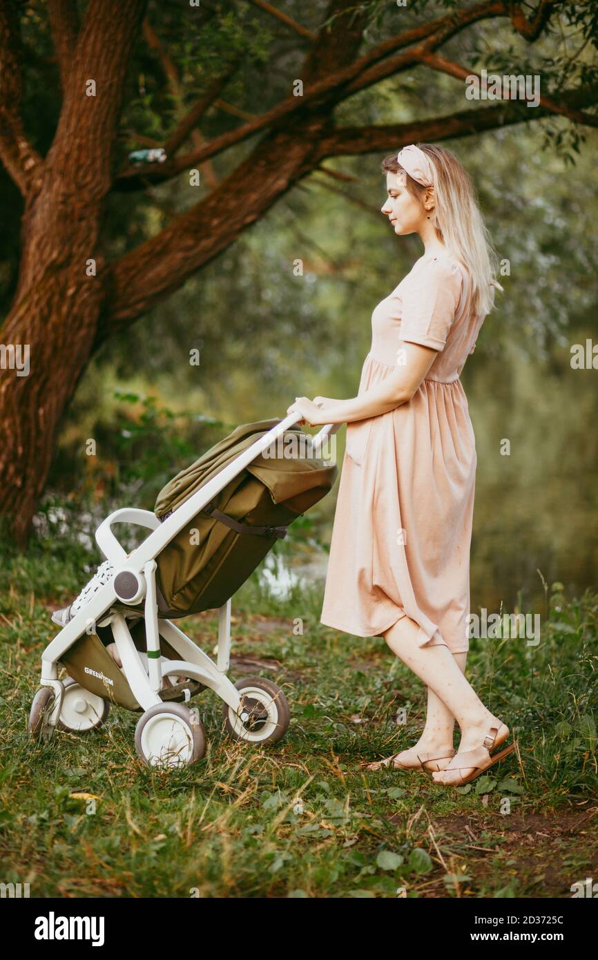 Happy young mother with baby in buggy walking Stock Photo - Alamy