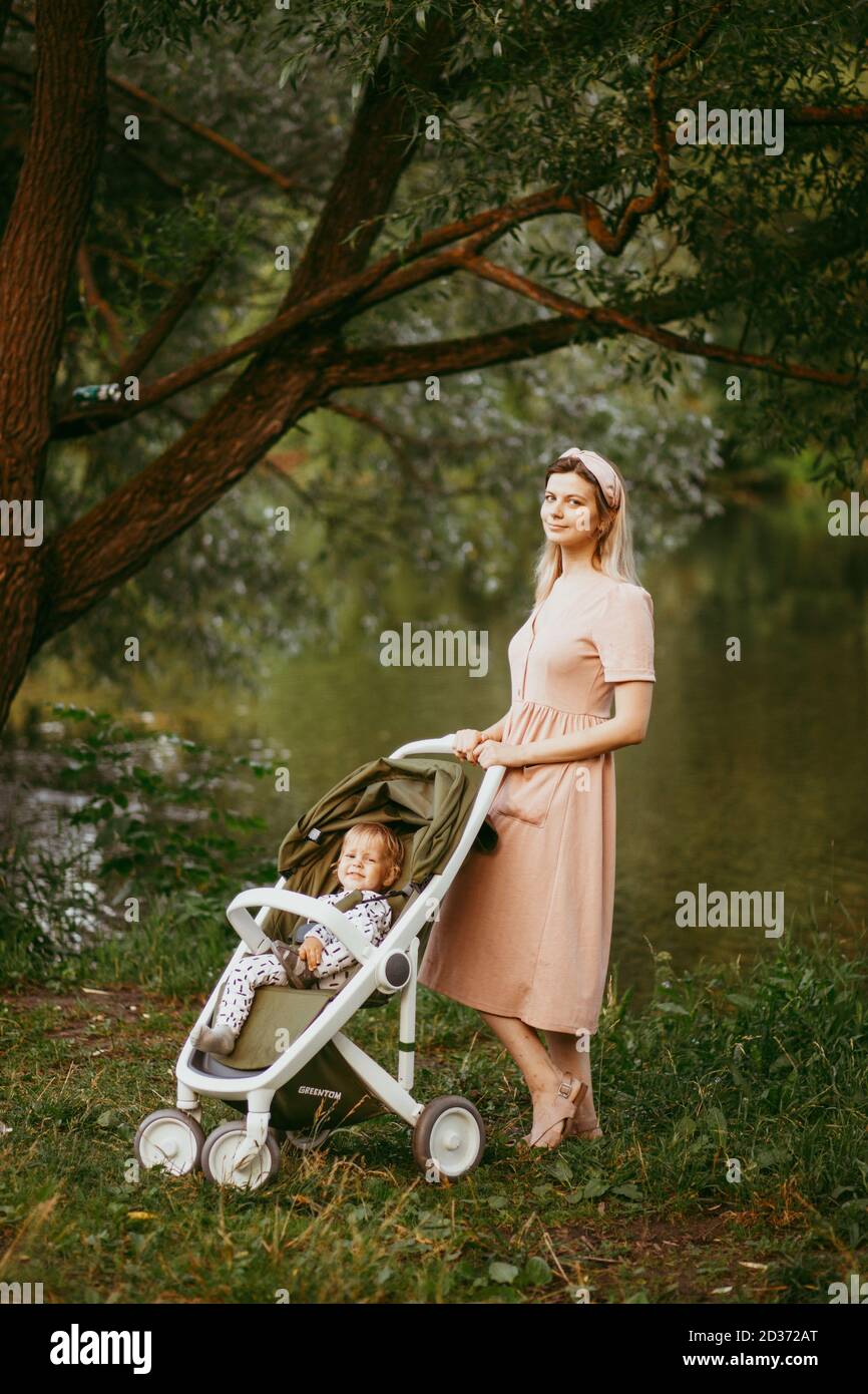Happy young mother with baby in buggy walking Stock Photo - Alamy