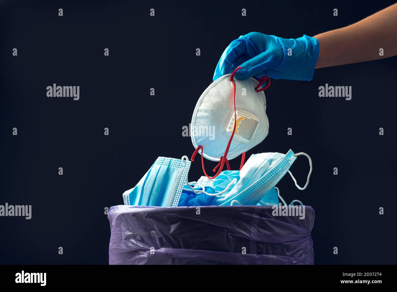 Hand putting used dirty surgical mask to a garbage bin Stock Photo - Alamy