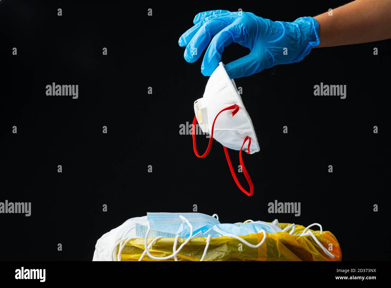 Hand putting used dirty surgical mask to a garbage bin Stock Photo - Alamy