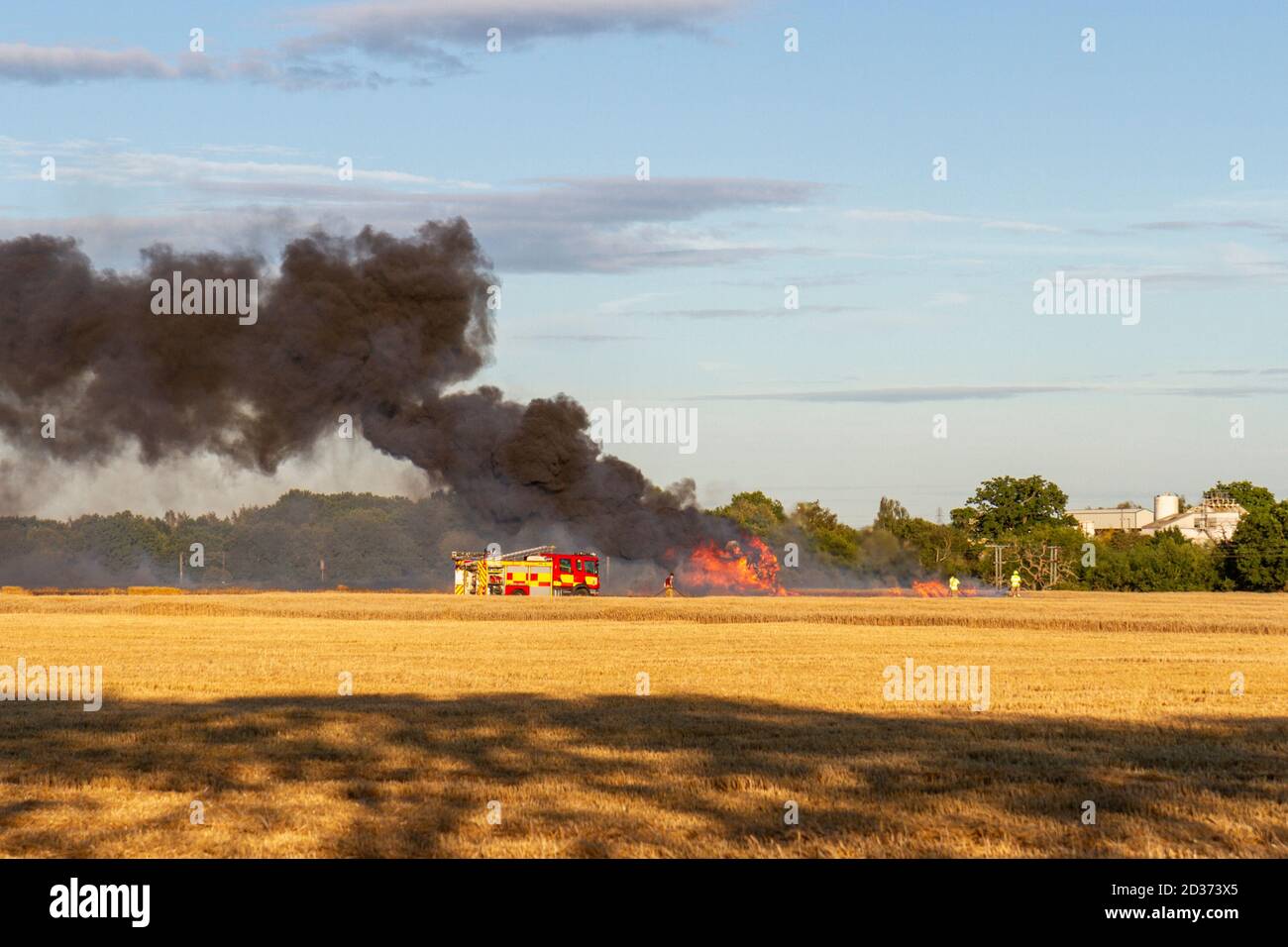 Smoke rising from a combine harvester with a fire engine in attendance ...