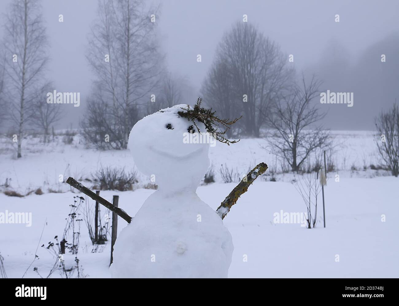 Funny snowman made by children on snow covered rural field Stock Photo ...