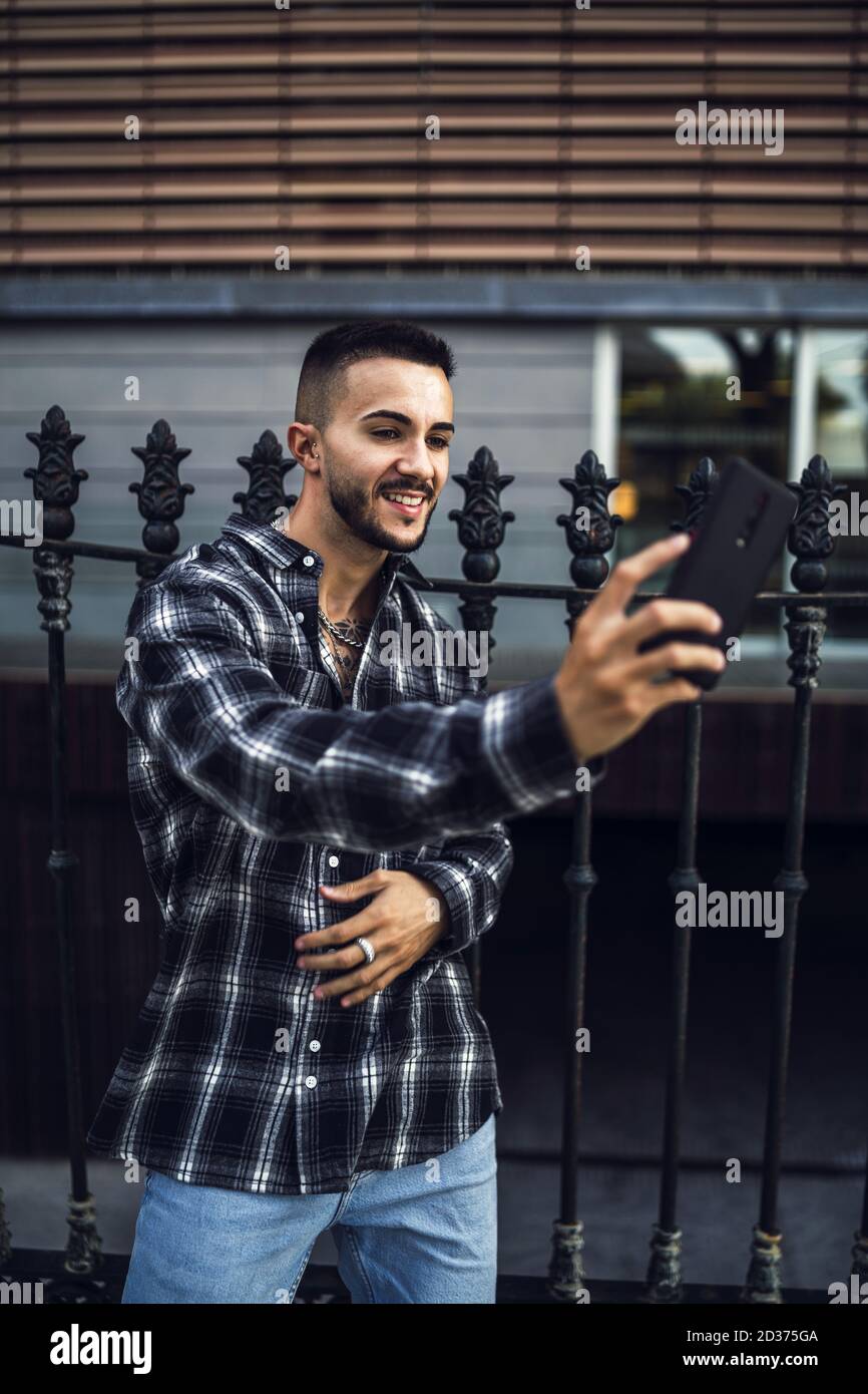 Young male with a beard wearing a black flannel shirt and jeans while ...