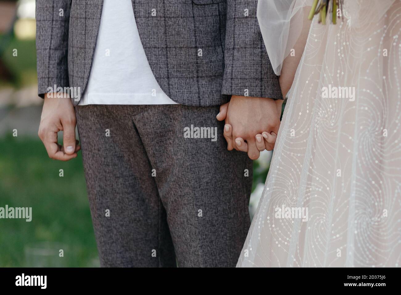 Faceless bride and groom holding each other hands. Hands of the happy ...