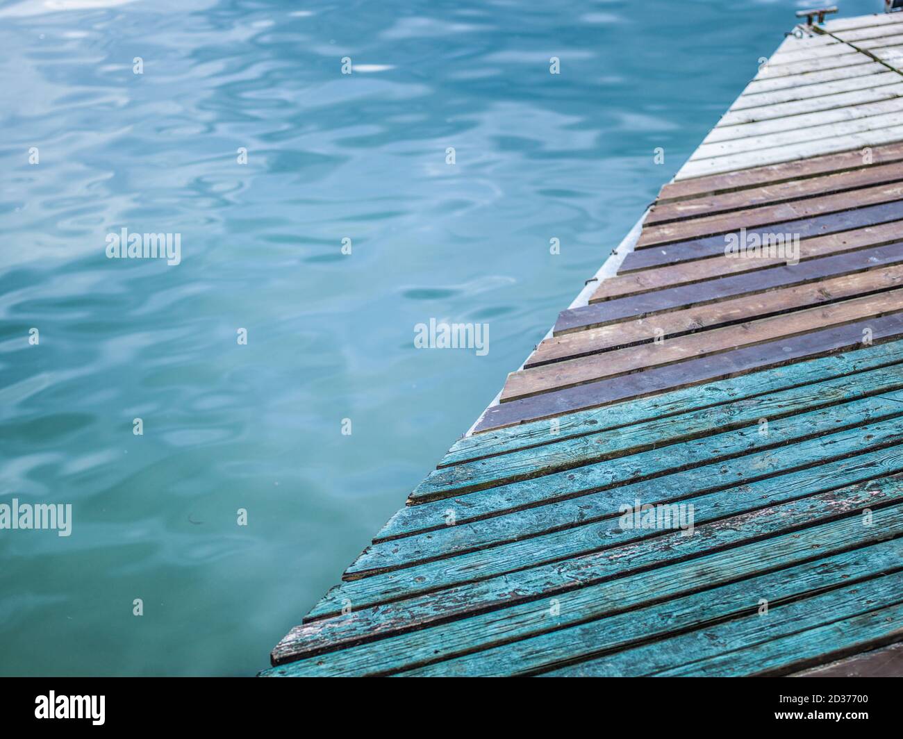 Closeup shot of a wooden colorful dock near blue water Stock Photo - Alamy