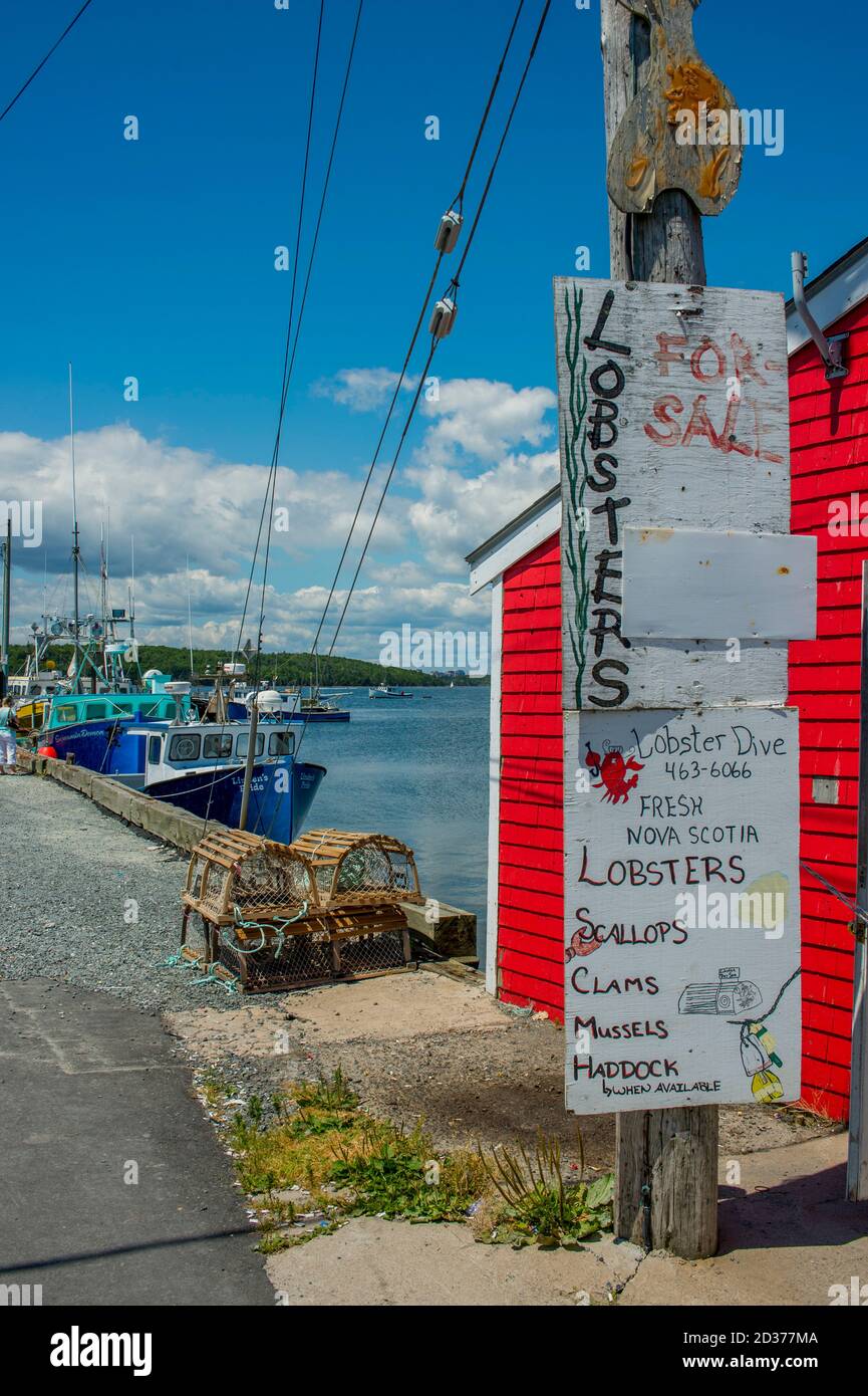 Fresh seafood sign with fishing boats in background at restored 19th ...