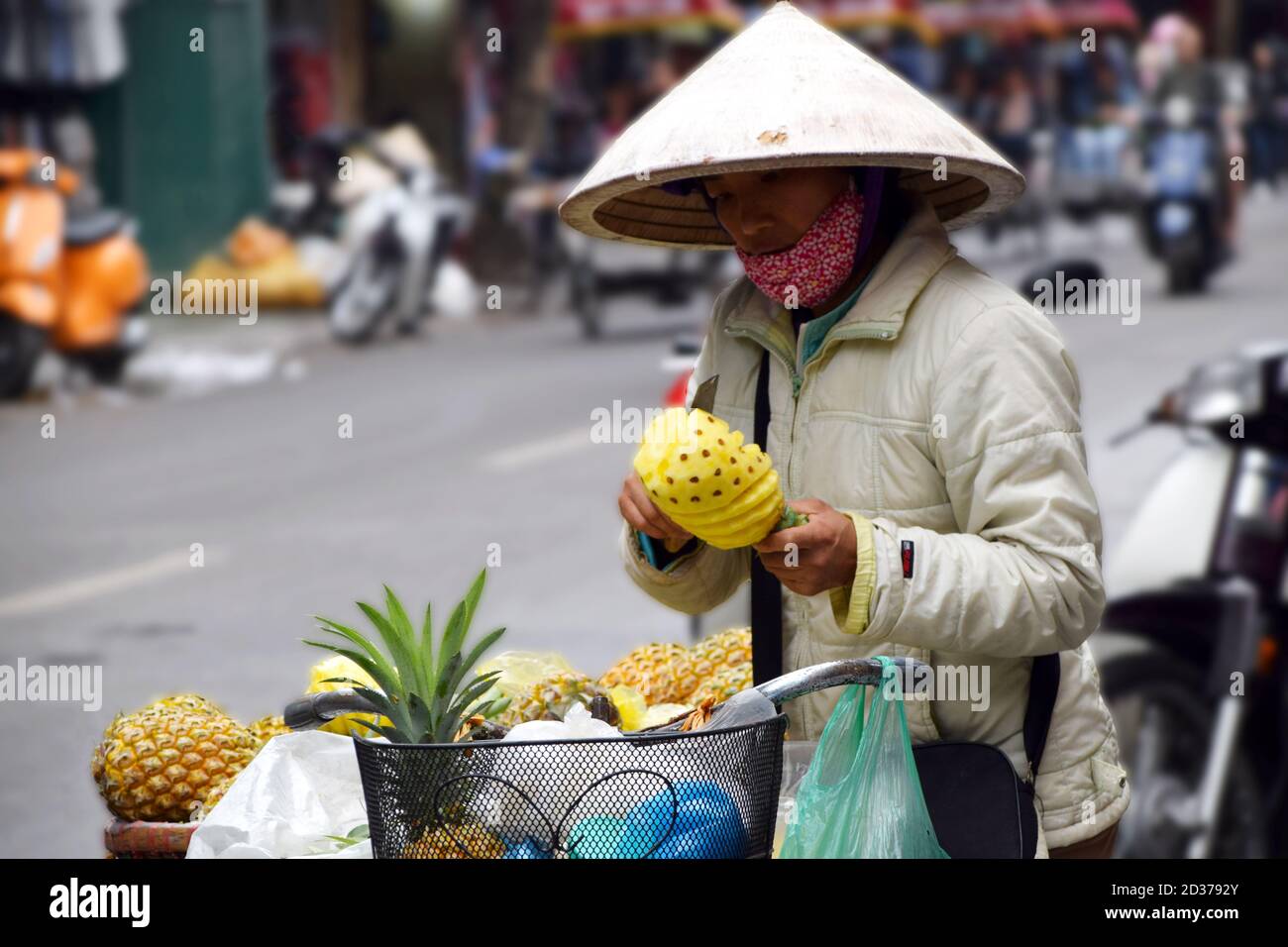 Vietnamese woman in Hanoi with traditional conical hat and face mask ...