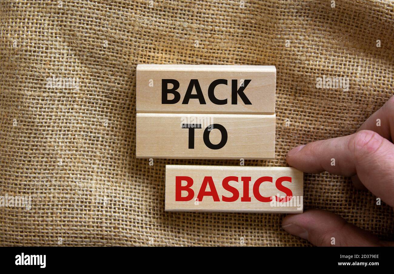 Wooden blocks form the words 'back to basics' on canvas background ...