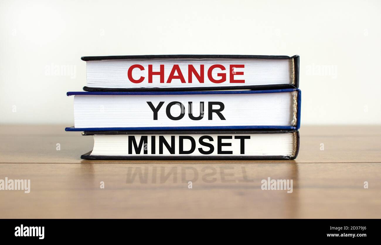 Books with text 'change your mindset' on beautiful wooden table, white ...