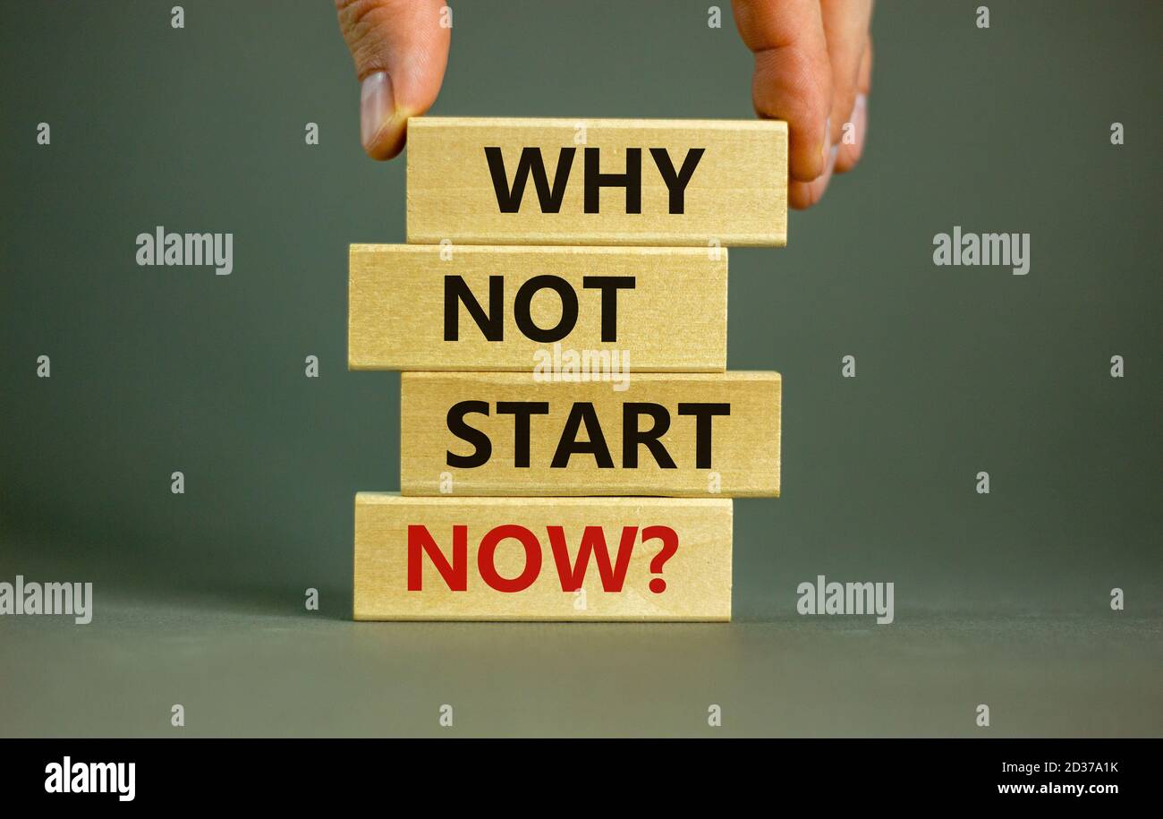 Male hand placing a block with word 'now' on a blocks tower with words ...