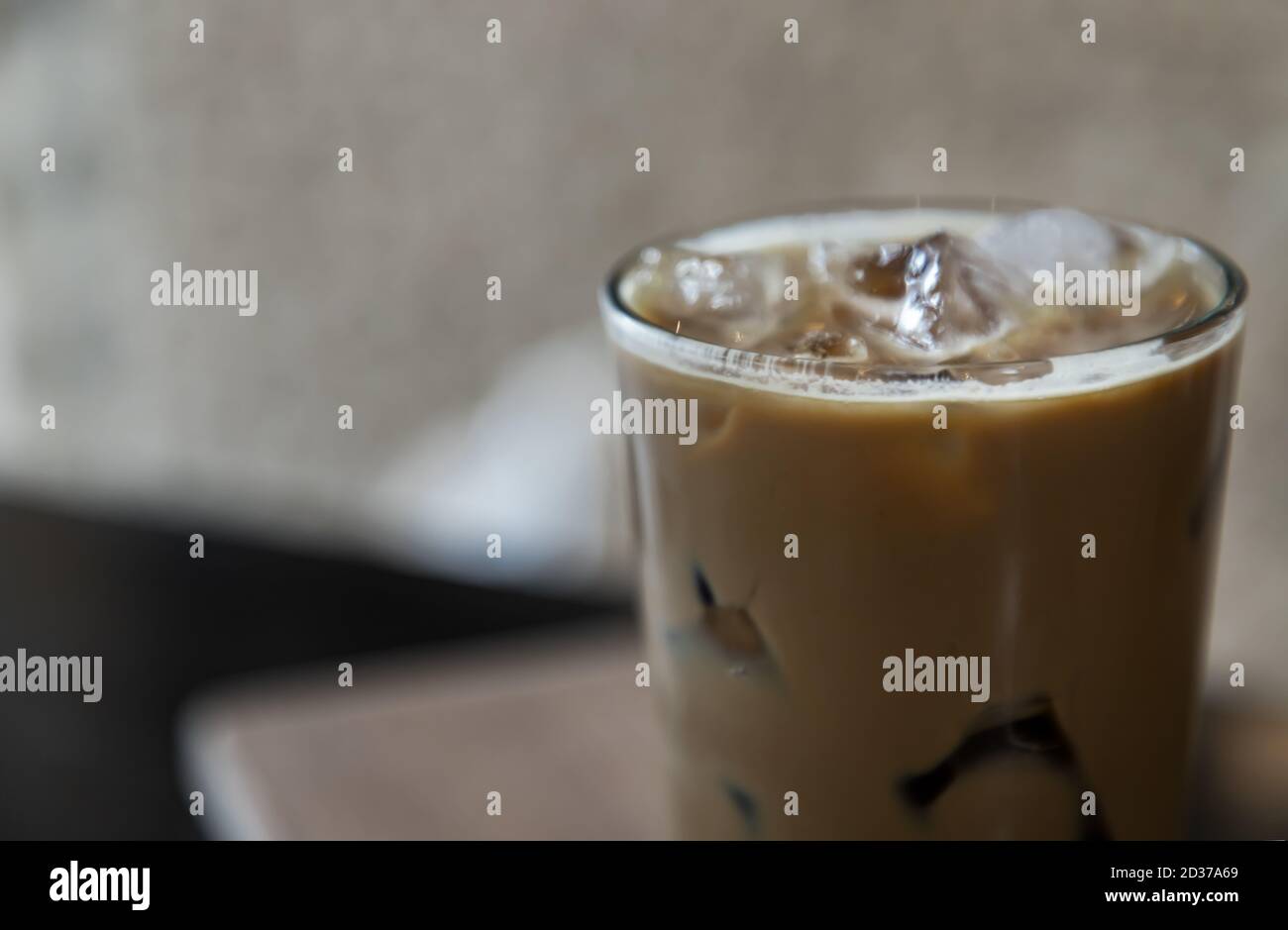 Cold coffee in a tall glass with ice cubes on wooden background. Cold ...