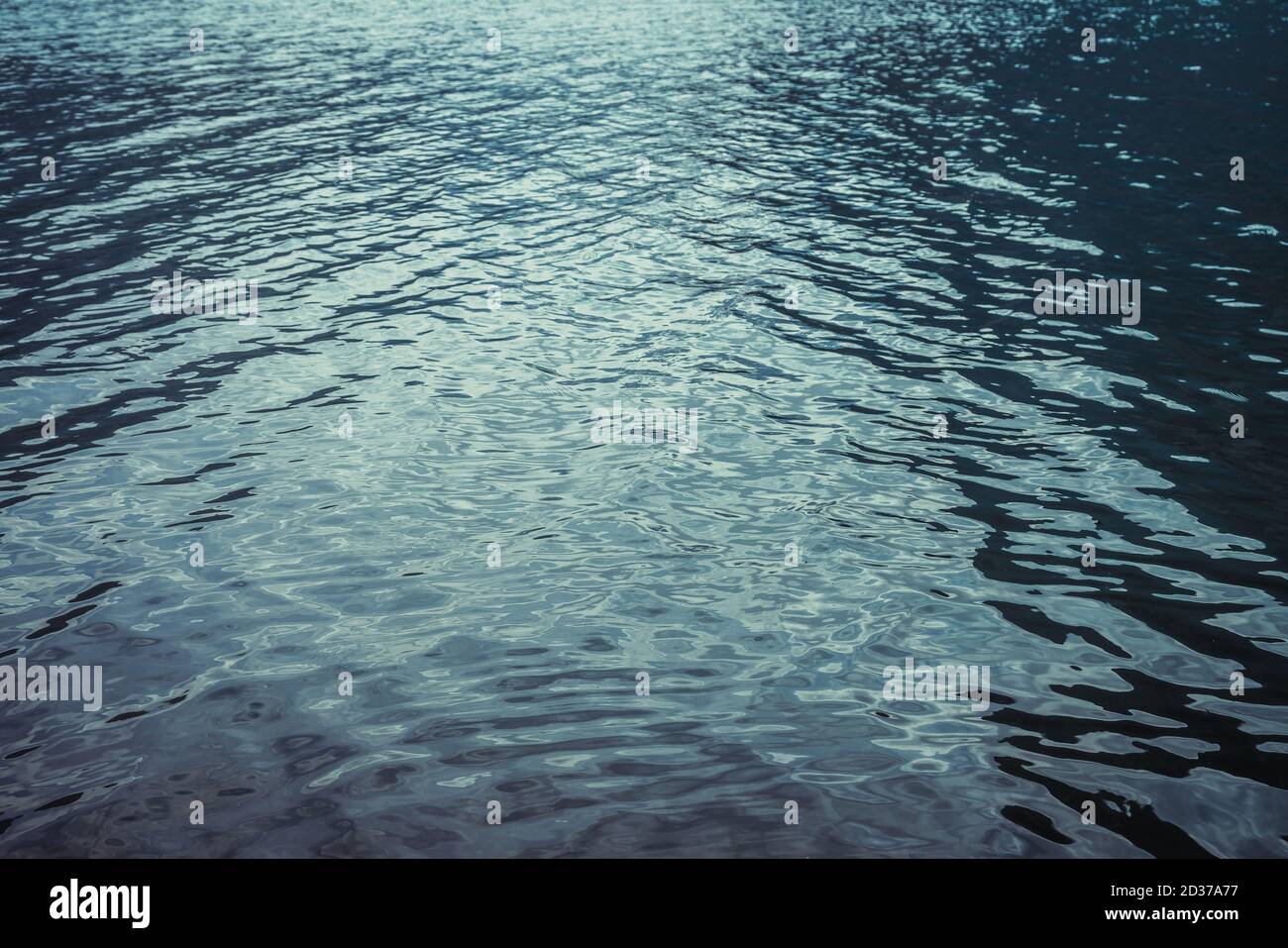 Texture of purple calm water of mountain lake. Meditative ripples on ...