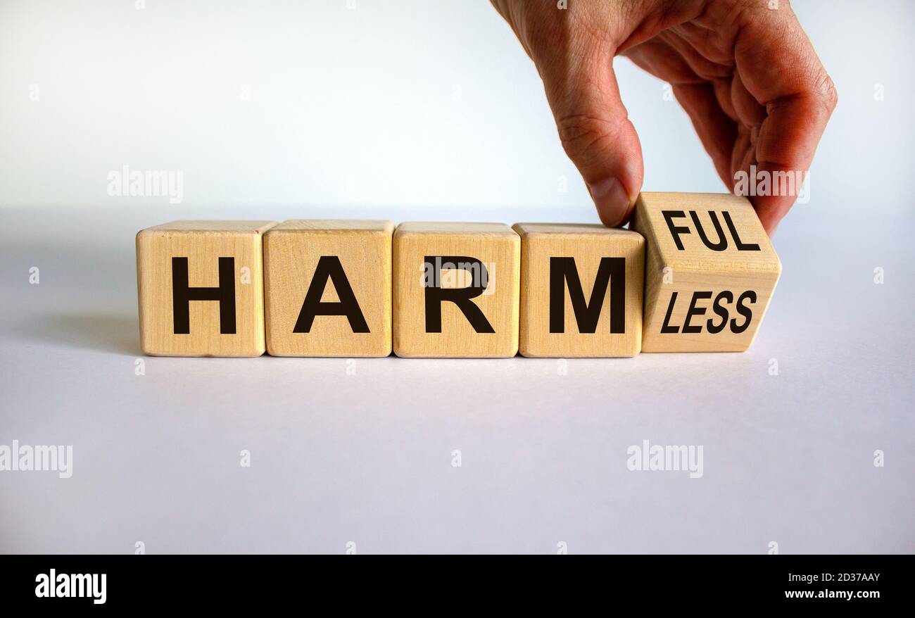 Male hand turns the cube and changes the expression 'harmless' to ...