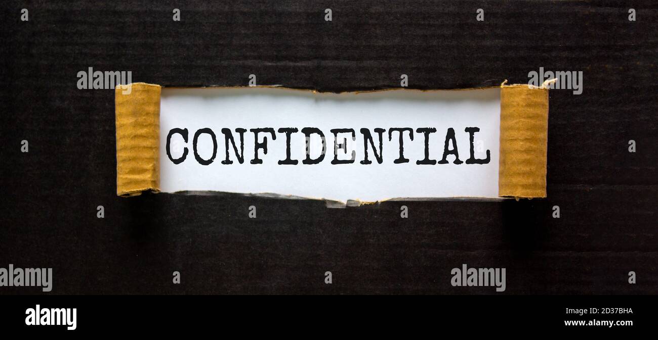 The word 'confidential' appearing behind torn black paper. Business ...