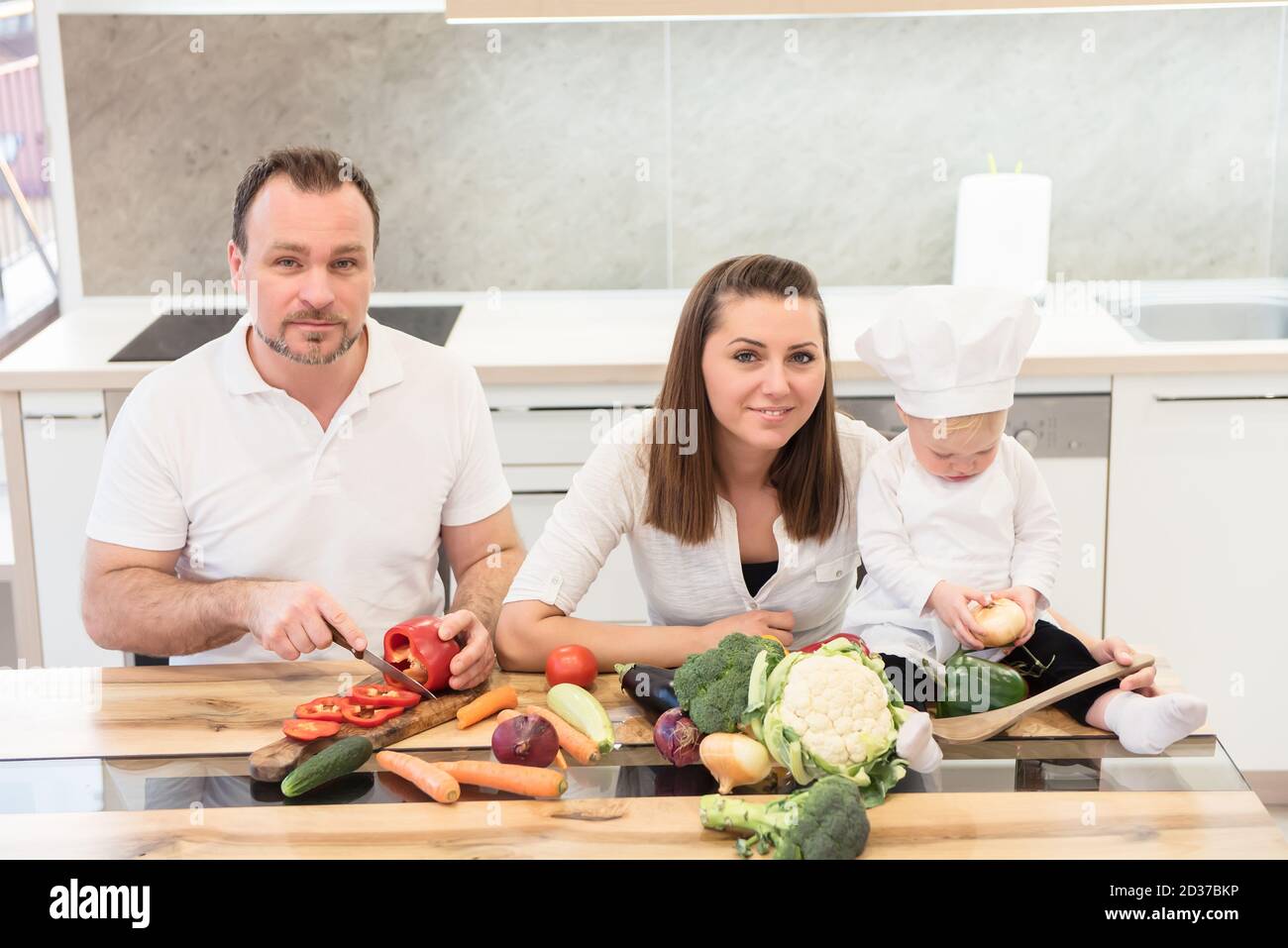 Happy parents sitting in the kitchen and prepares for cooking with ...