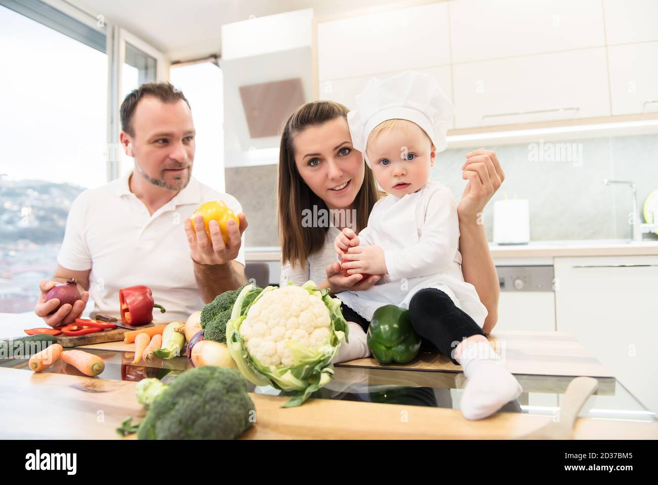Happy parents sitting in the kitchen and prepares for cooking with ...