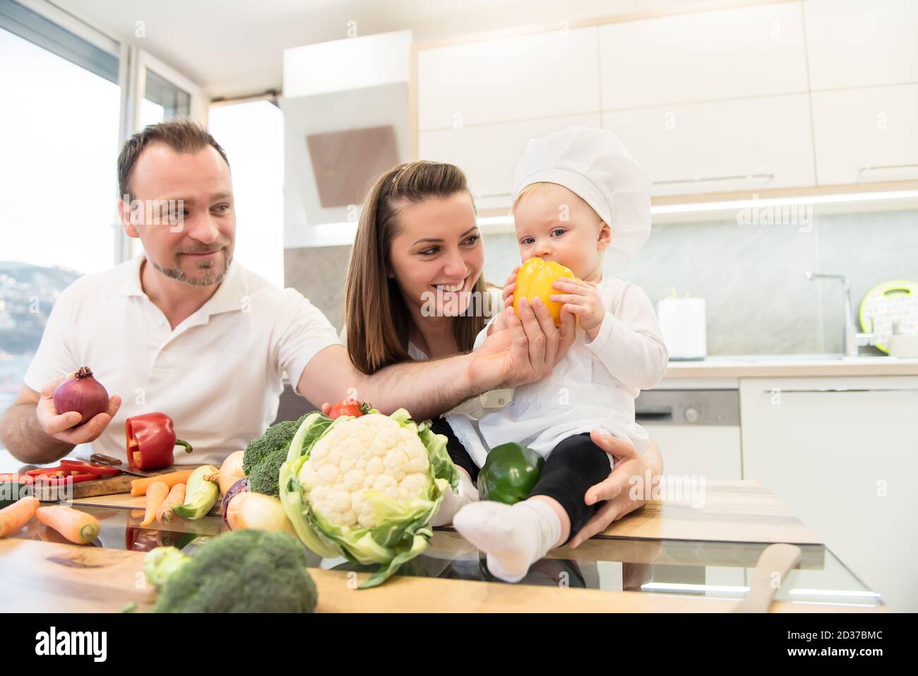 Happy parents sitting in the kitchen and prepares for cooking with ...