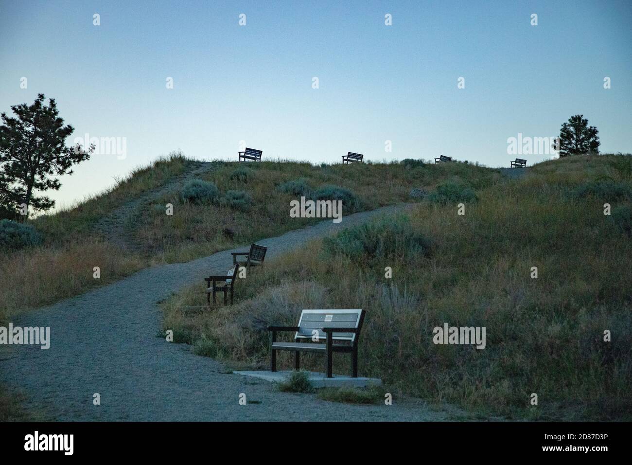 Empty benches winding up a mountain path Stock Photo - Alamy