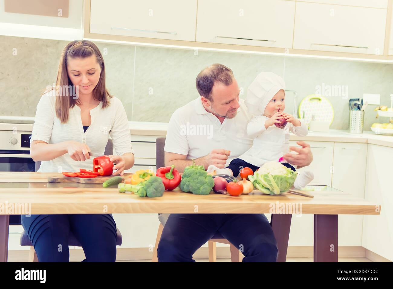 Happy parents sitting in the kitchen and prepares for cooking with ...