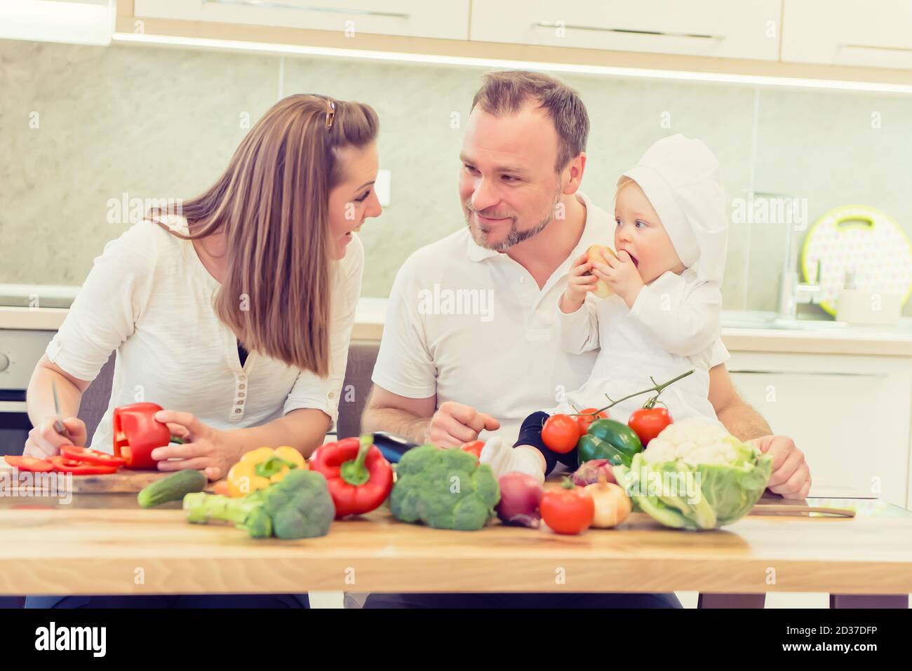 Happy parents sitting in the kitchen and prepares for cooking with ...