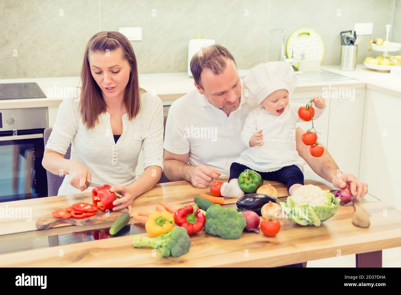 Happy parents sitting in the kitchen and prepares for cooking with ...