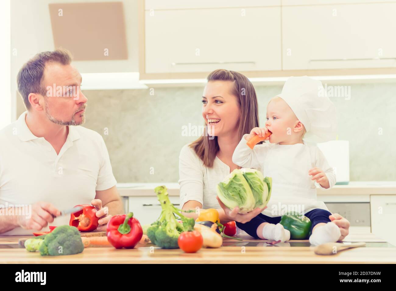 Happy parents sitting in the kitchen and prepares for cooking with ...