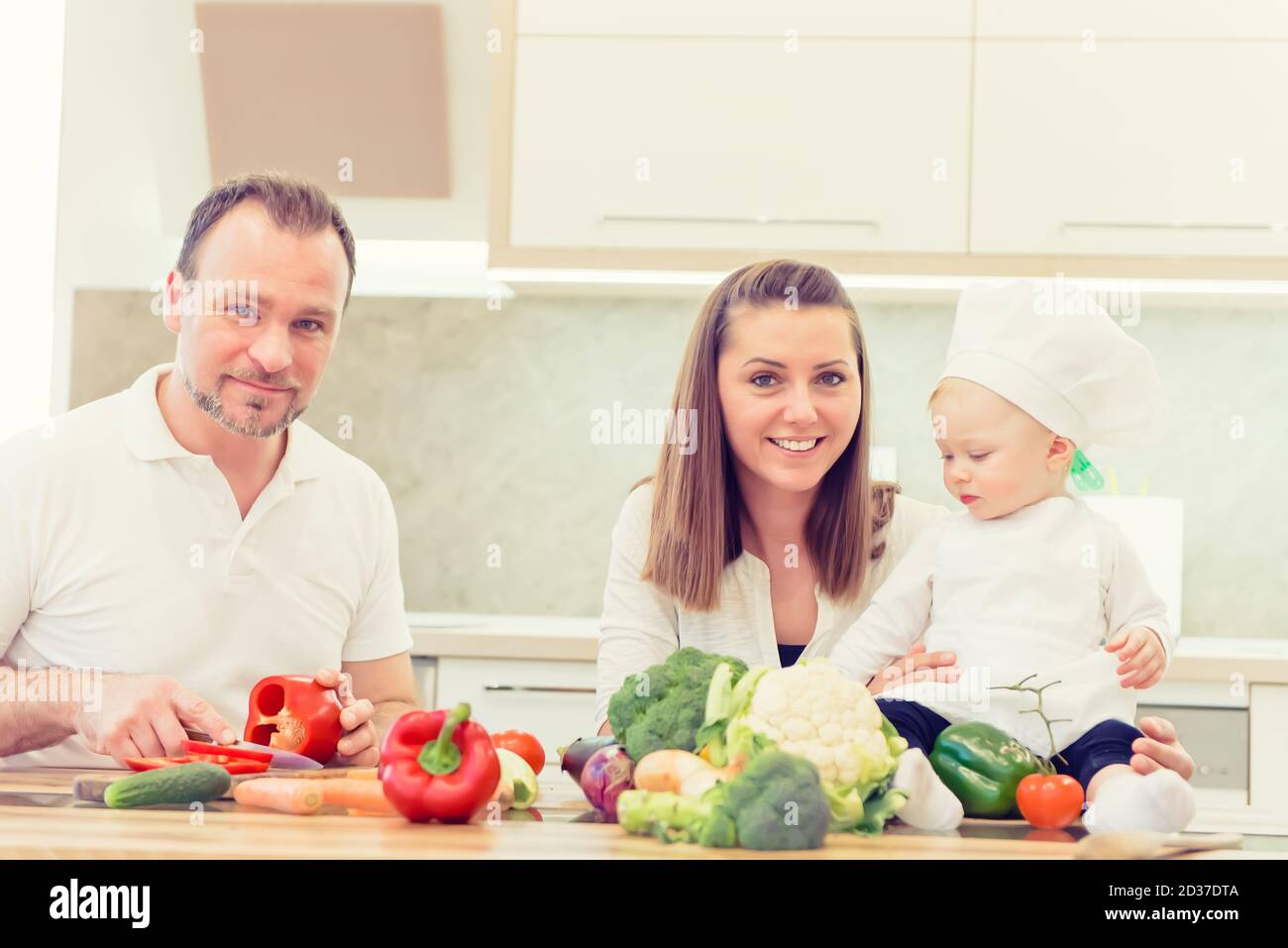 Happy parents sitting in the kitchen and prepares for cooking with ...