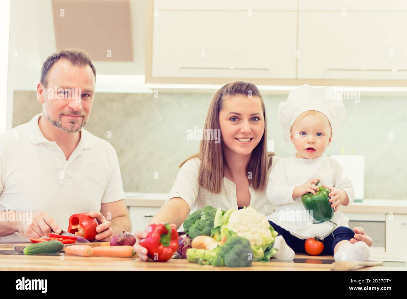 Happy parents sitting in the kitchen and prepares for cooking with ...