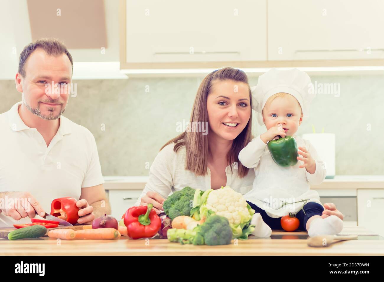 Happy parents sitting in the kitchen and prepares for cooking with ...