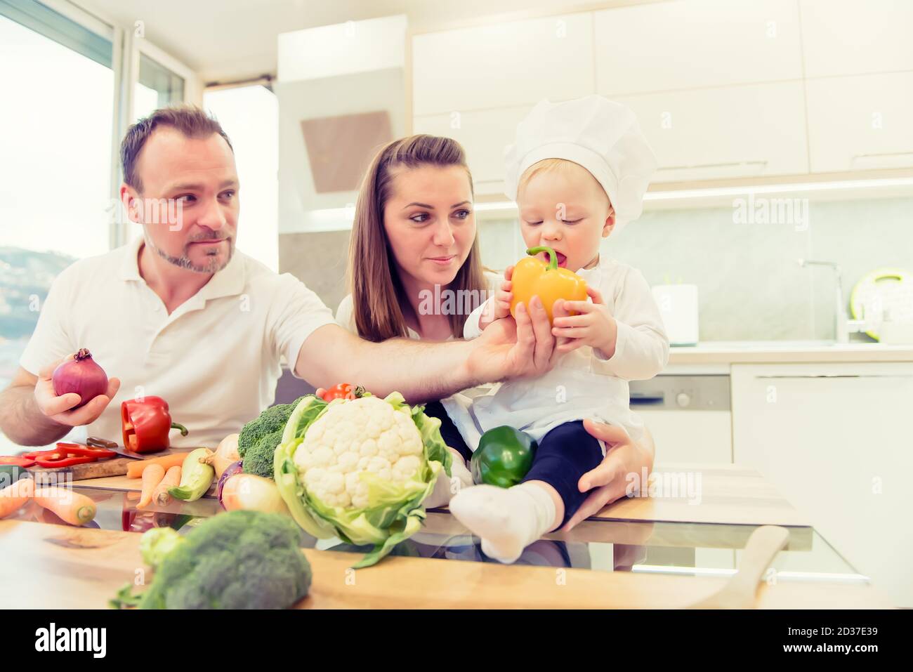 Happy parents sitting in the kitchen and prepares for cooking with ...