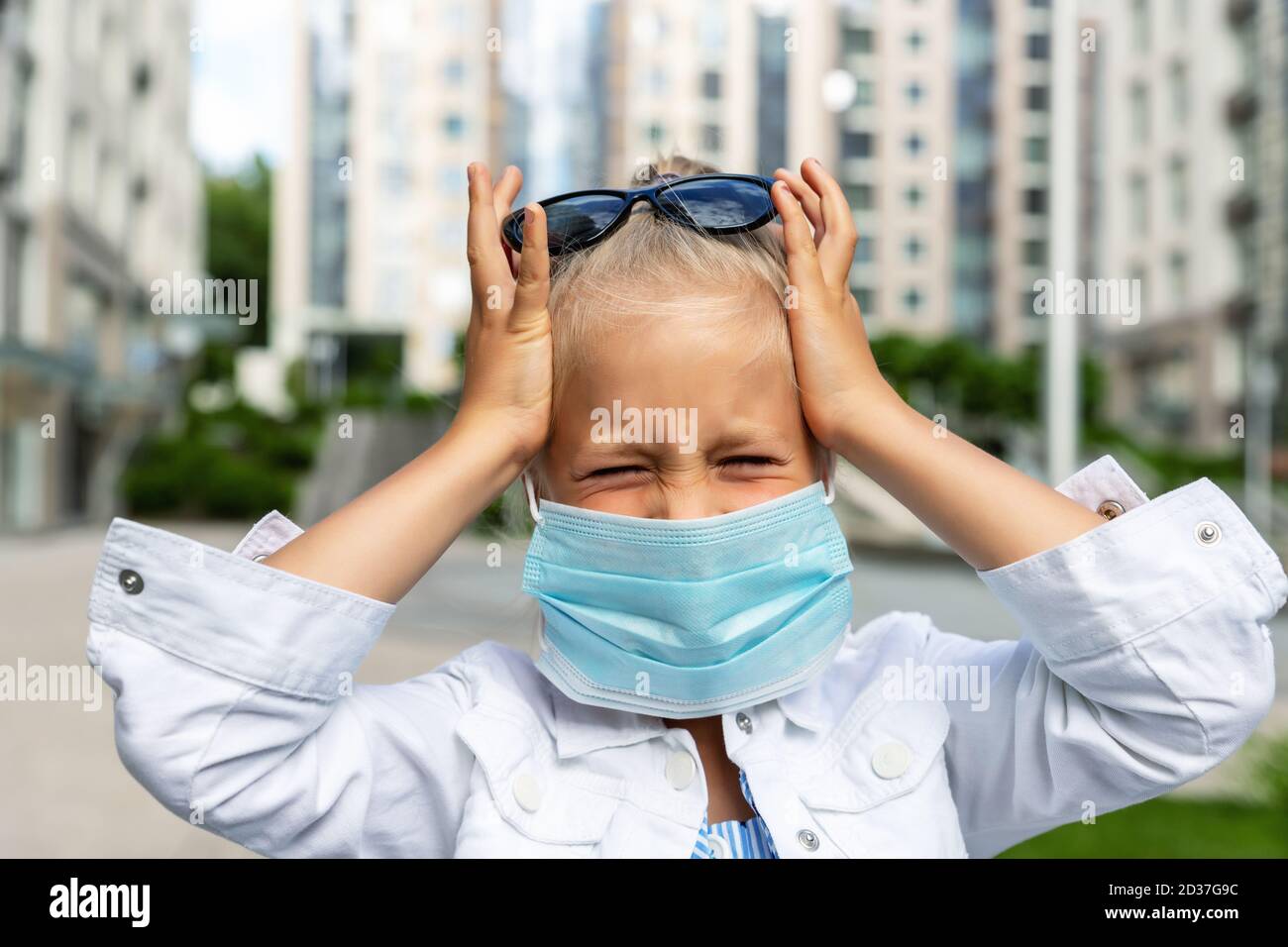 Little blond caucasian girl wearing protective face mask feel stressed ...