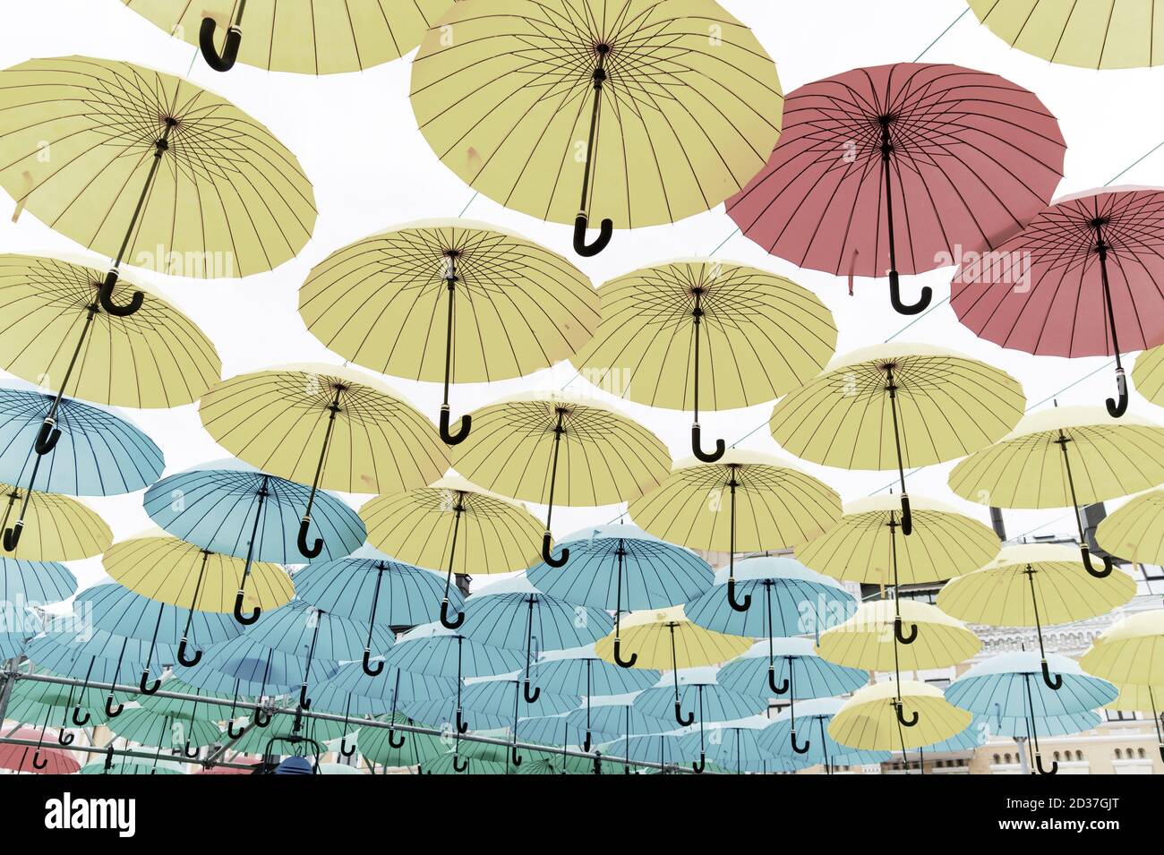 Collection of multi colored umbrellas hanging up in an open position ...