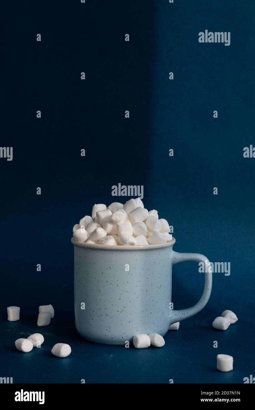 marshmallows in a cup against dark blue background Stock Photo - Alamy