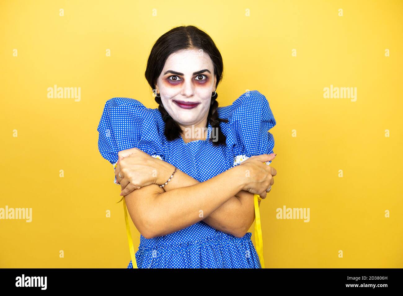 woman wearing a scary doll halloween costume over yellow background ...
