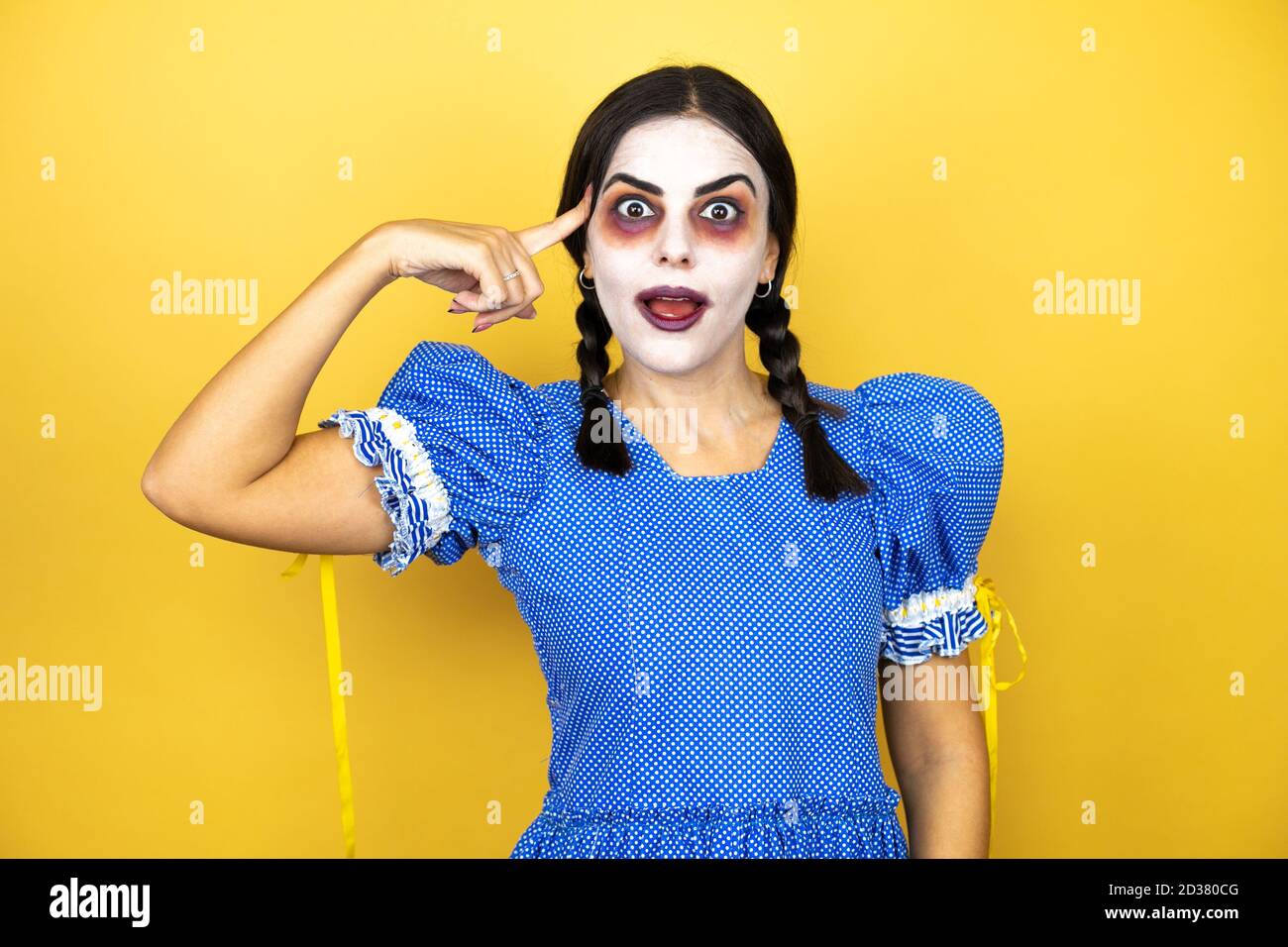 woman wearing a scary doll halloween costume over yellow background ...
