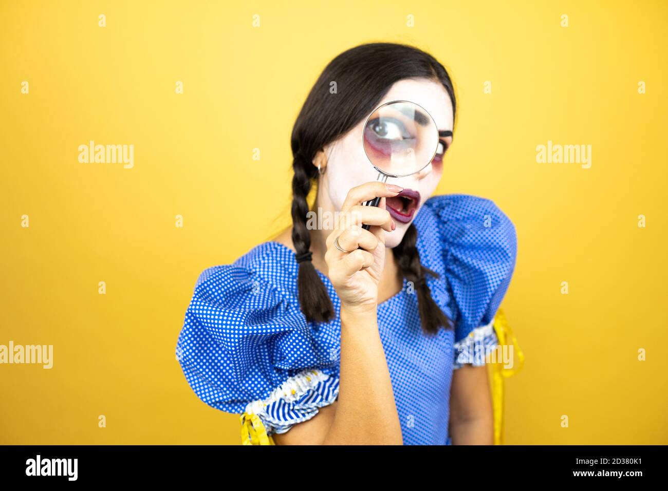 woman wearing a scary doll halloween costume over yellow background ...