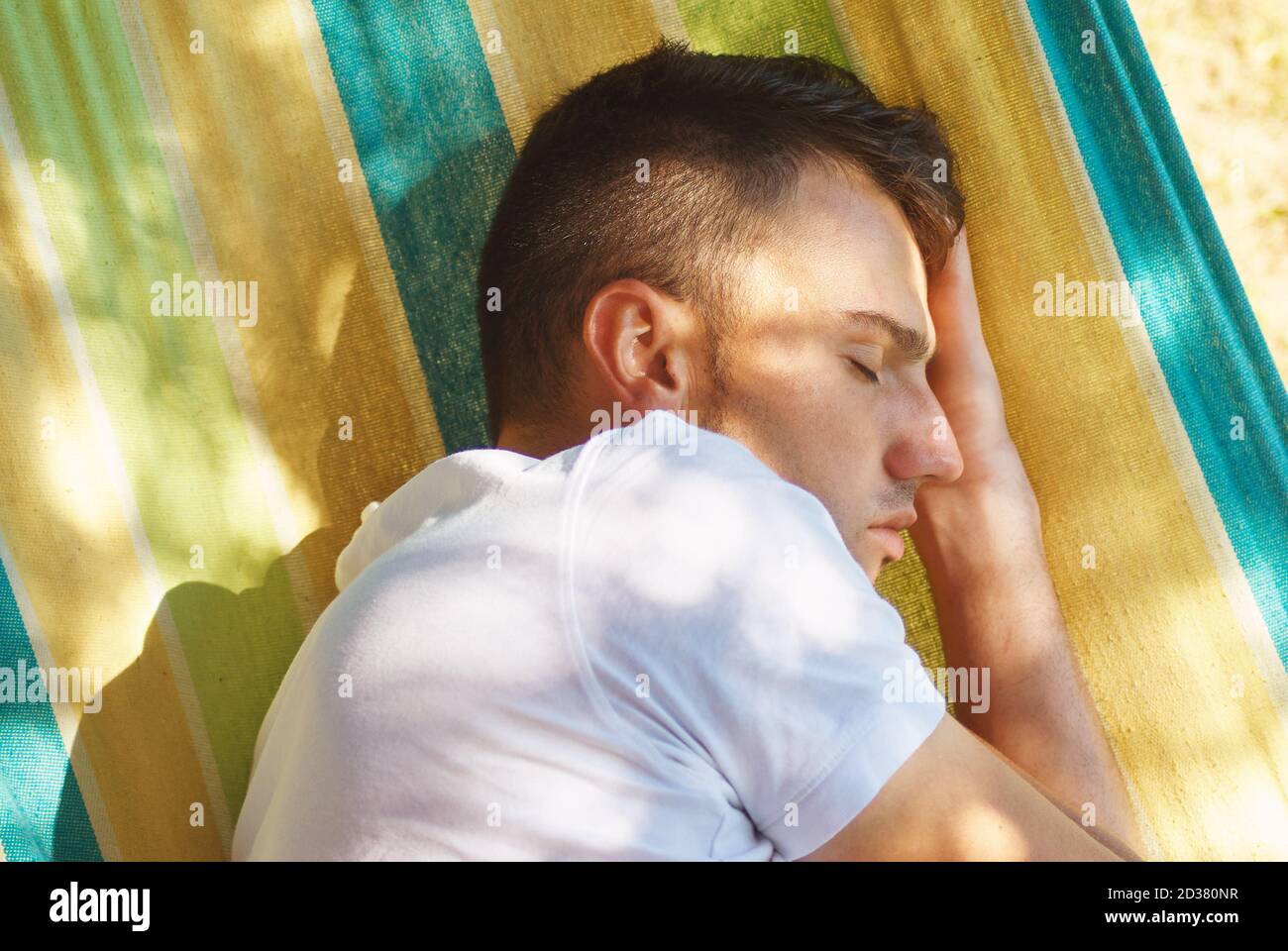 Young man laying on hanging chair and enyoing sunlight Stock Photo - Alamy