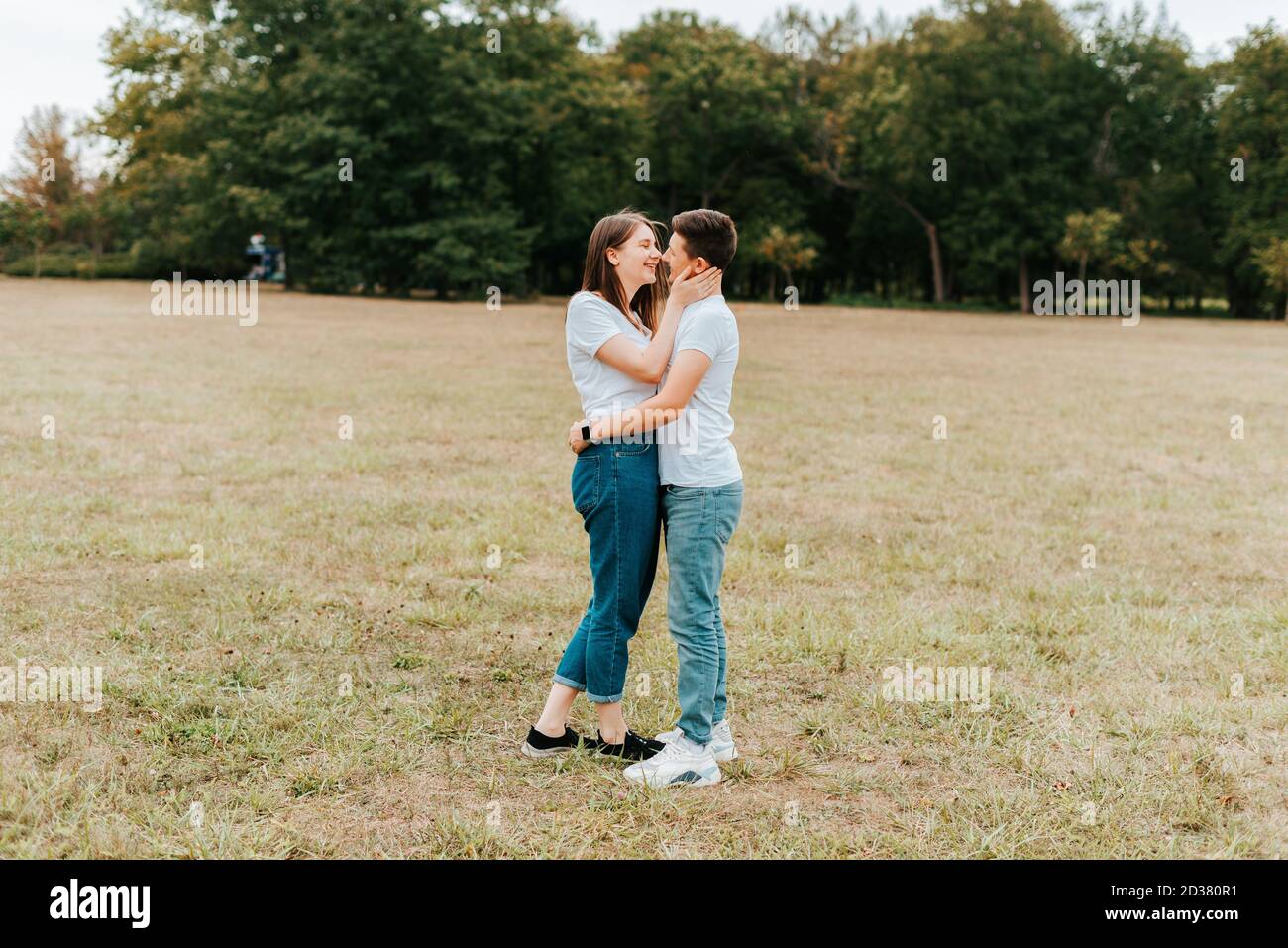 Photo of young couple embracing outdoor in park Stock Photo - Alamy