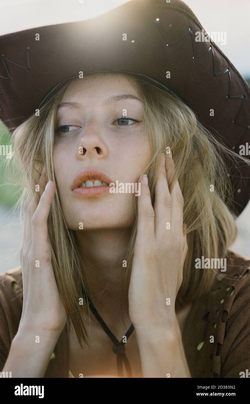 Close-up face of hippie woman in cowboy hat at sunset in meadow Stock ...