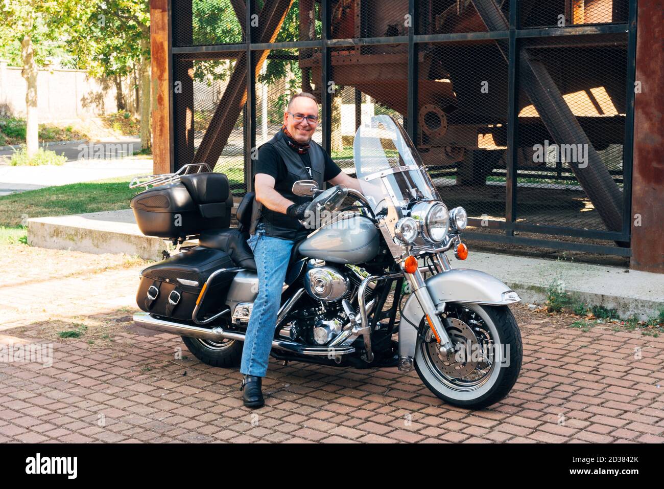a biker posing smiling on his custom motorcycle Stock Photo - Alamy