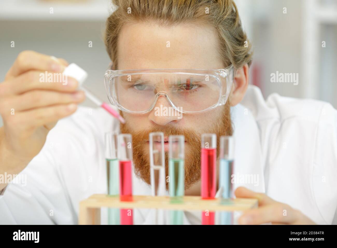 close view of male scientist dripping liquid into test-tube Stock Photo ...