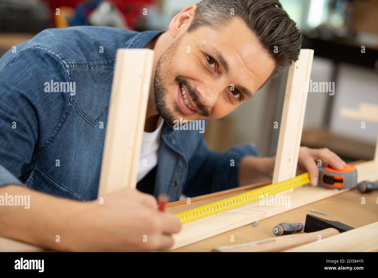 a carpenter uses a framing square for marking a furniture Stock Photo ...